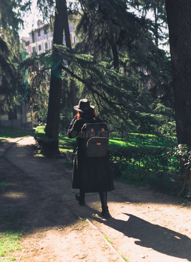 Vertical Back View of a Young Female Wearing Black Coat and Backpack in ...