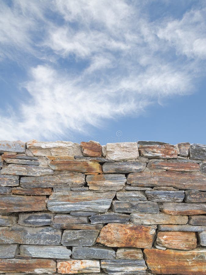 Vertical Background with Rough Stone Wall and Blue Cloudy Sky Stock ...