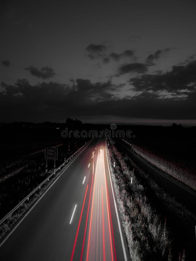 Vertical Black and White Shot of Red Traffic Light Trails a Road in the ... Vertical Black and White Shot of Red Traffic Light Trails a Road in the ...
