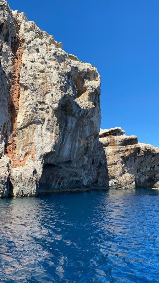 Vertical of a Blue Sea Under a Tall Cliff Stock Image - Image of ...