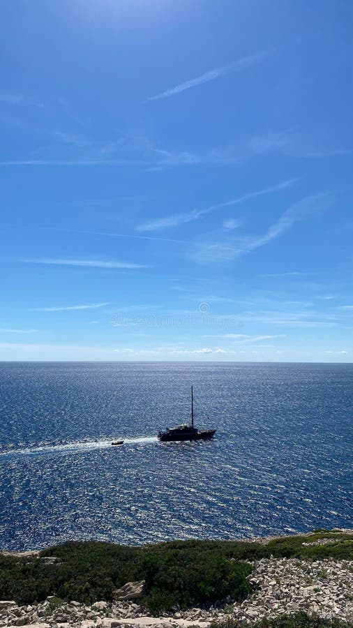 Vertical of a Boat Sailing in a Blue Open Sea Under the Blue Sky Stock ...