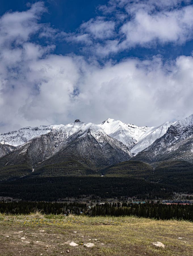 Vertical of Canmore Snow-capped Mountains with a Cloudy Sky in the ...