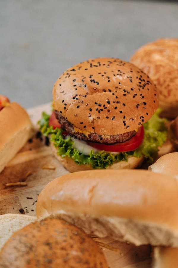 Vertical of a Cheeseburger and Bread Next To it. Stock Photo - Image of ...