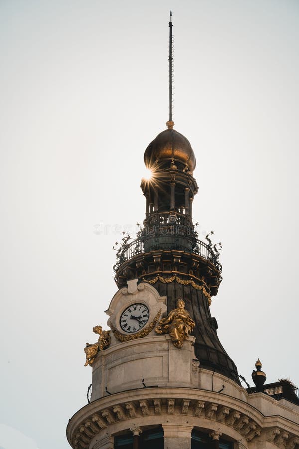 Vertical of a Clock Tower with Golden Sculptures in the Sunlight Stock ...