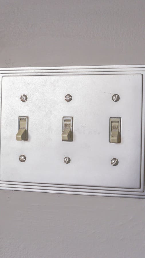 Vertical Close Up of the Electrical Light Switch Against the White Wall ...