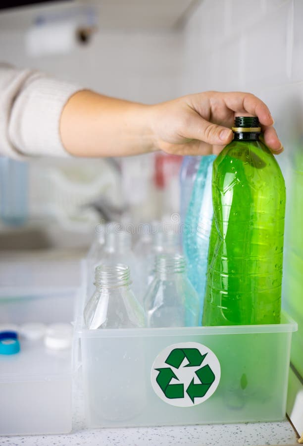 Vertical. Close-up. a Hand Puts a Plastic Bottle into a Box with a ...
