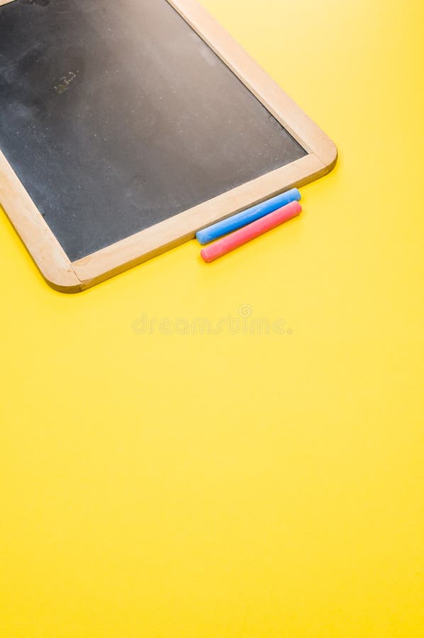 Vertical Closeup of a Blackboard with Chalks on a Yellow Surface Stock ...