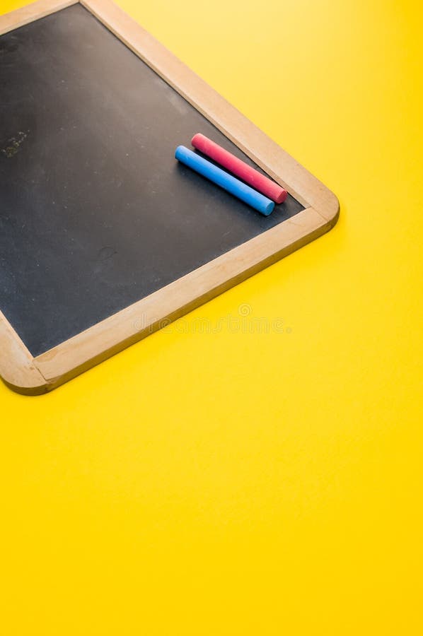 Vertical Closeup of a Blackboard with Chalks on a Yellow Surface Stock ...