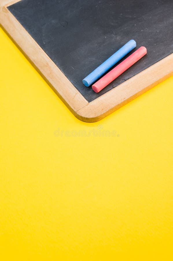 Vertical Closeup of a Blackboard with Chalks on a Yellow Surface Stock ...