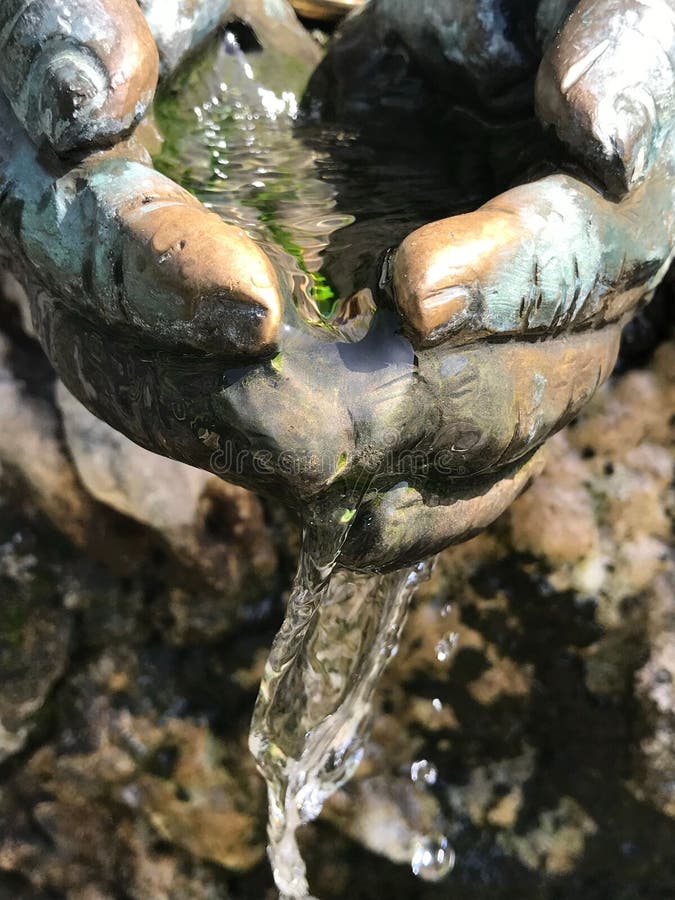Vertical Closeup of a Bronze Sculpture of Hands Holding Water Stock ...