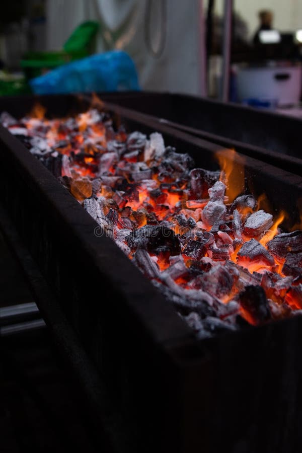 Vertical Closeup of Fire in a Grill Outdoors with a Blurred Background ...