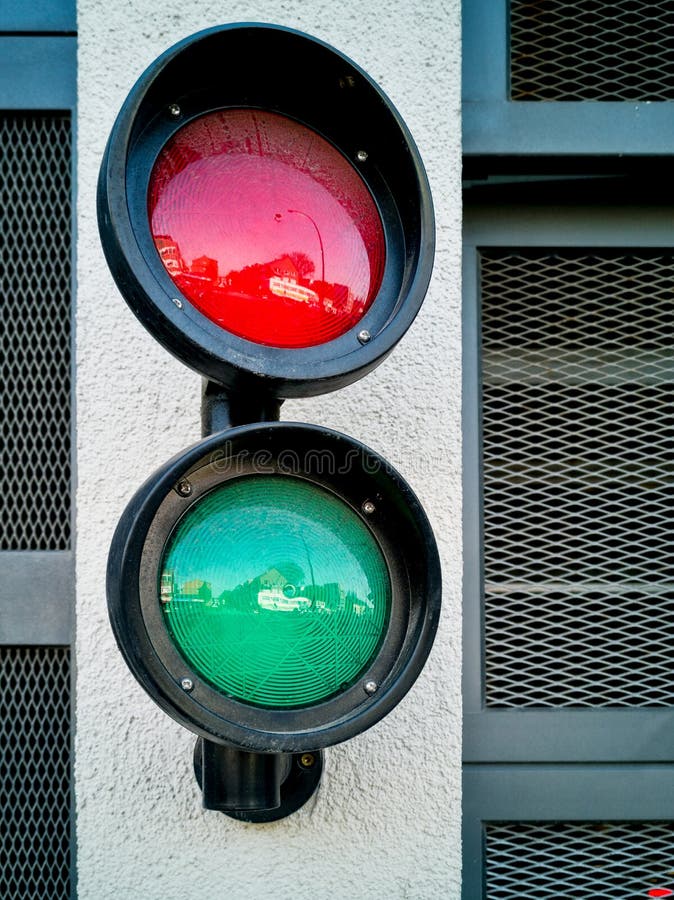 Vertical Closeup of a Red and Green Traffic Light on a White Wall ...