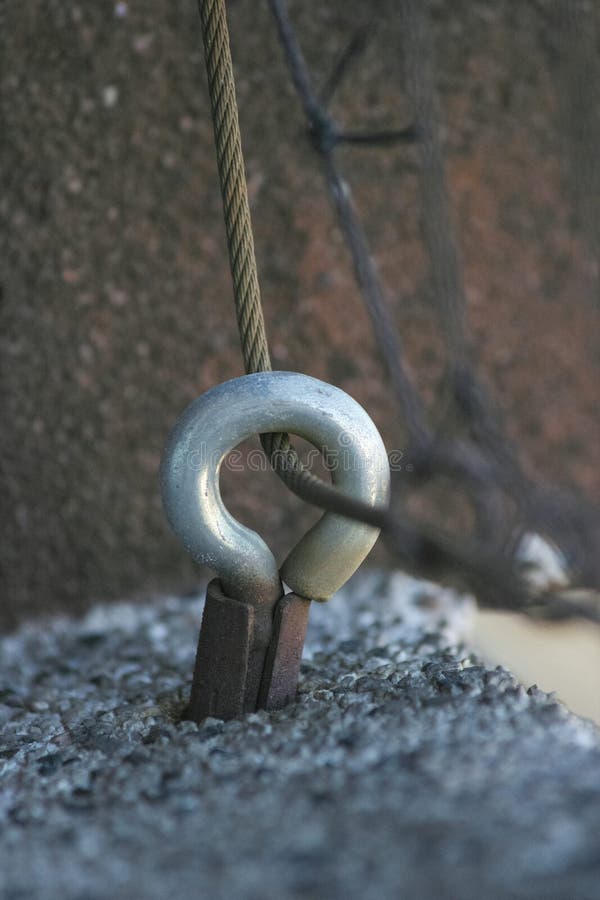 Vertical Closeup of a Rusty Metallic Hook Holding a Wire, Punched into ...