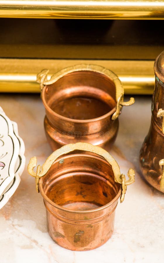 Vertical Closeup Shot of Antique Bronze Containers on a White Surface ...