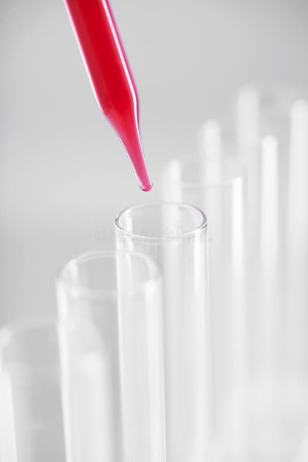 Vertical Closeup Shot of a Dropper with Red Liquid Over Clean Test ...