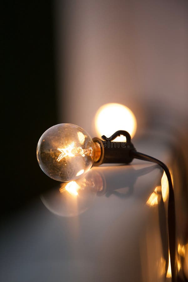 Vertical Closeup Shot of an Illuminated Lightbulb with a Cord on a ...