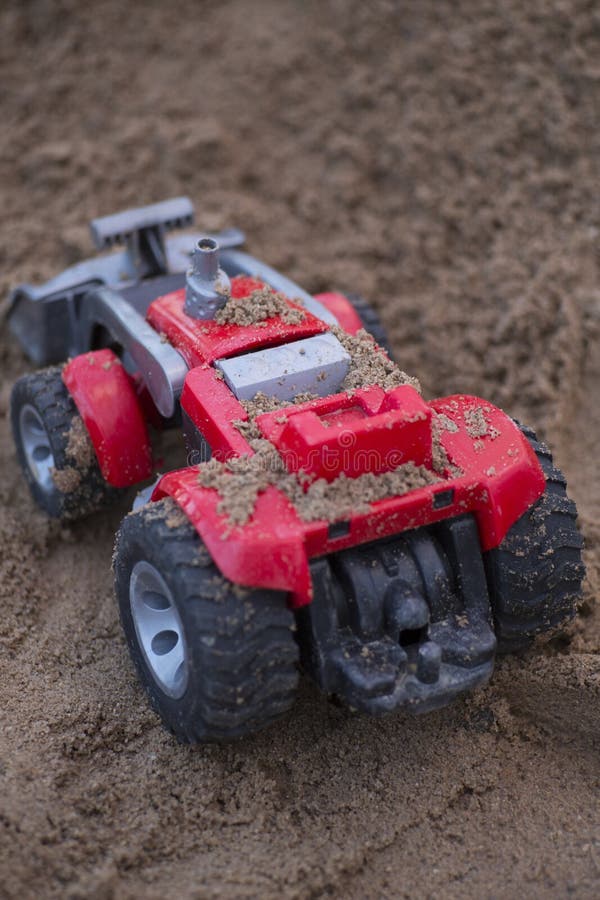 Vertical Closeup Shot of a Red Radio-controlled Car Covered with Sand ...