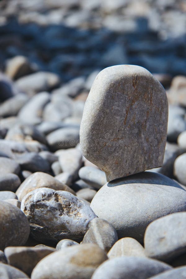 Vertical Closeup Shot of a Standing Out Pebble on the Pebble Ground ...
