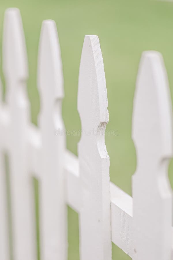 Vertical Closeup Shot of a White Picket Fence on a Green Background ...