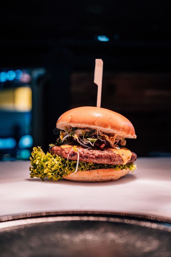 Vertical Closeup of a Tasty Burger on the Table. Stock Image - Image of ...