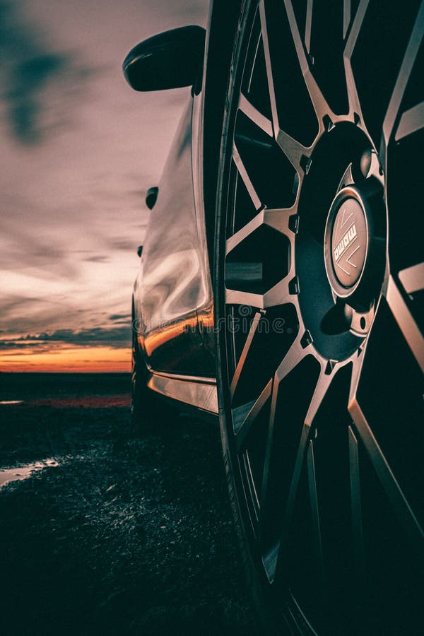 Vertical Closeup of the Wheel Rim of a Car with Sunset Reflection on it ...