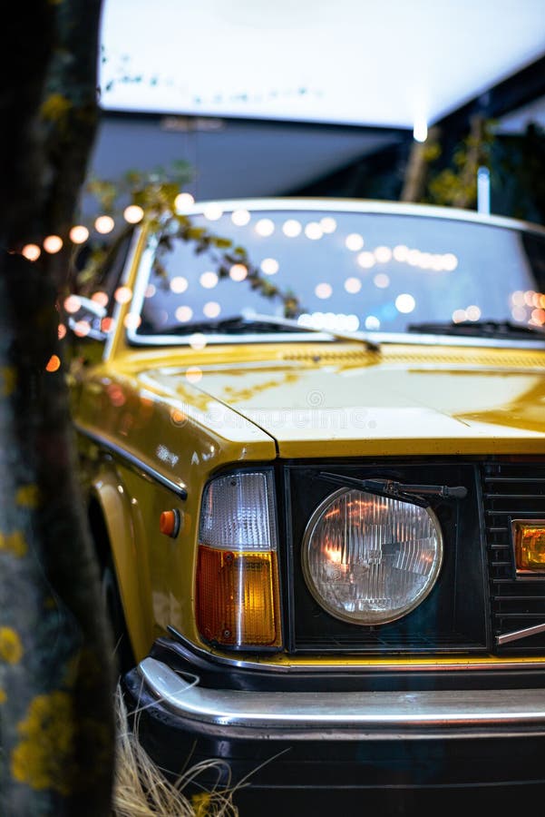 Vertical Closeup of a Yellow Car with Lights Reflecting on Its ...