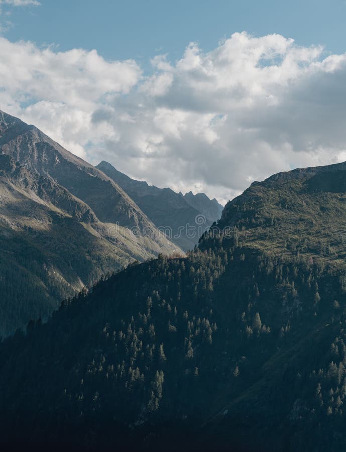 Vertical De Montanhas Arborizadas Com Nuvens E Fundo Azul Imagem de ...