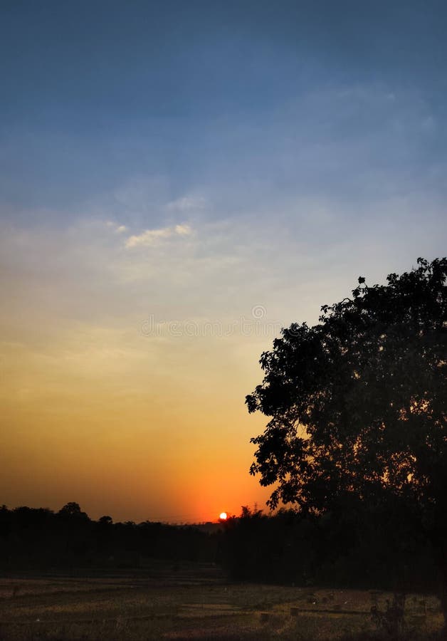 Vertical of the Glowing Distant Sun Going Behind a Hill at Sunset ...