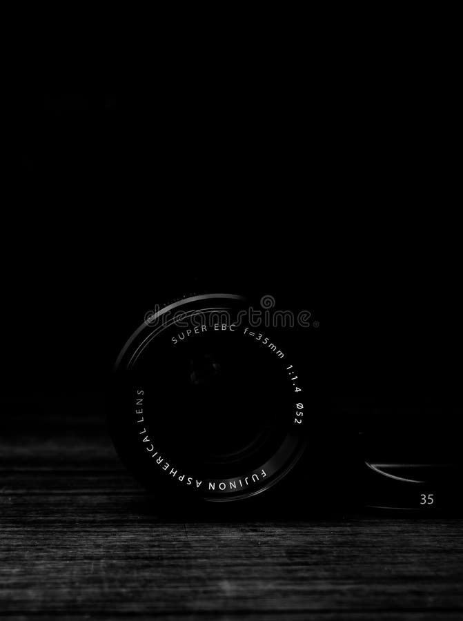 Vertical Gray Scale Shot of a Camera Lens on a Wooden Surface Stock ...