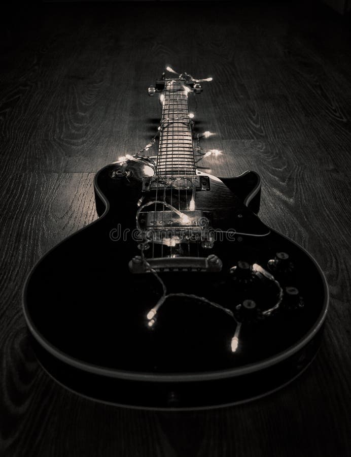 Vertical Grayscale Shot of a Black Electric Guitar Covered in Led ...