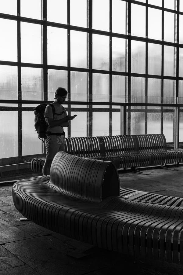Vertical Grayscale Shot of a Man with a Backpack at a Train Station ...