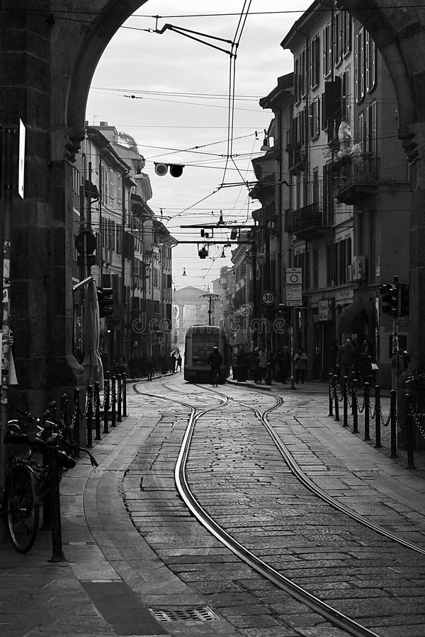 Vertical Grayscale Shot of a Tram-train on a Rail Near Buildings ...
