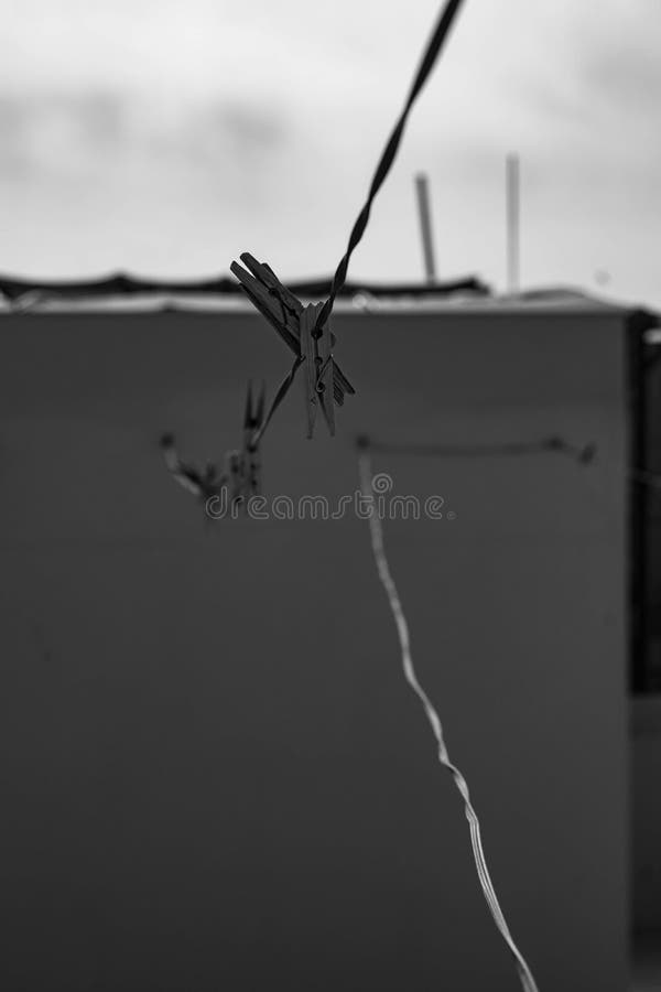 Vertical Grayscale Shot of a Washing Line with Hangers Outdoors during ...