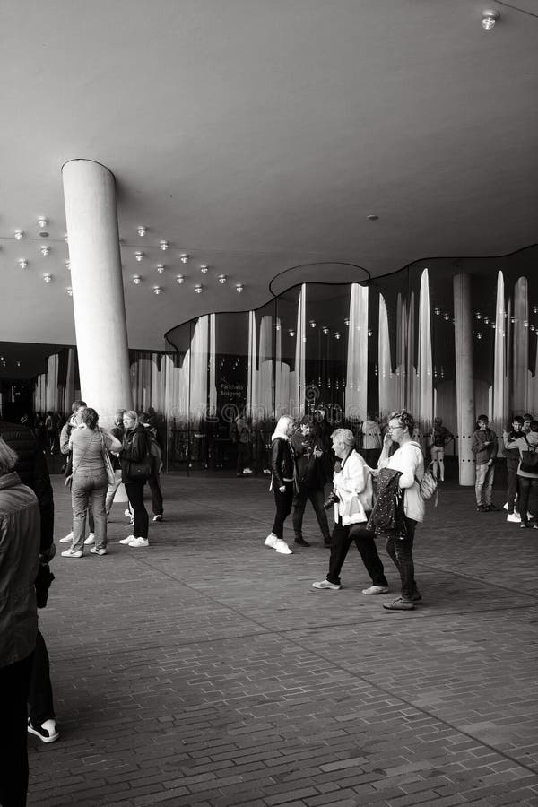Vertical Grayscale View of People Walking before the Wavy Metal Facade ...