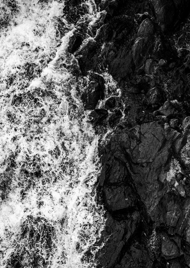 Vertical Grayscale of Waves Crashing into Rocks for Background Stock ...