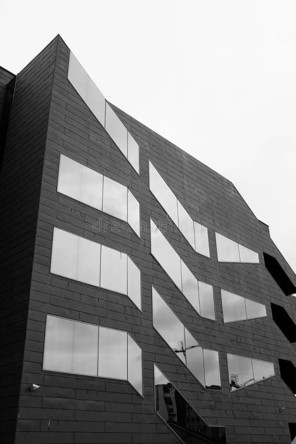Vertical Greyscale Shot of a Modern Concrete Building with Reflective ...