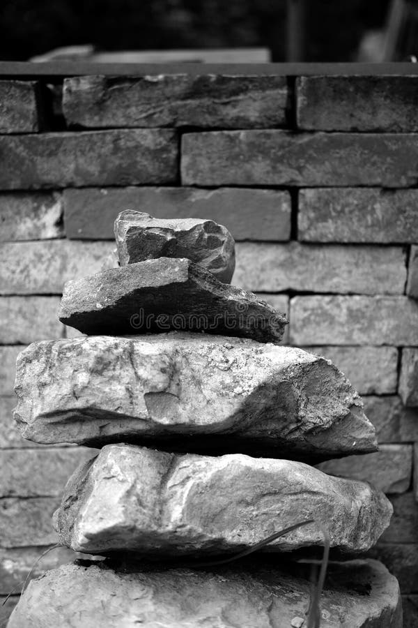 Vertical Greyscale Shot of Rough Stones on Top of Each Other with a ...