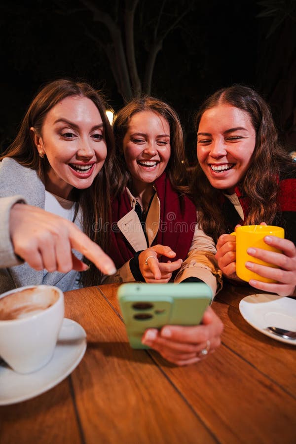 Vertical. Group of Young Women Smiling Sharing Media with an Cellphone ...