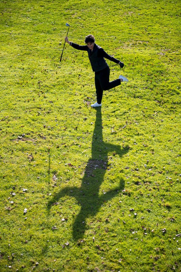 Vertical High Angle Shot of a Cheerful Female Playing Golf during ...