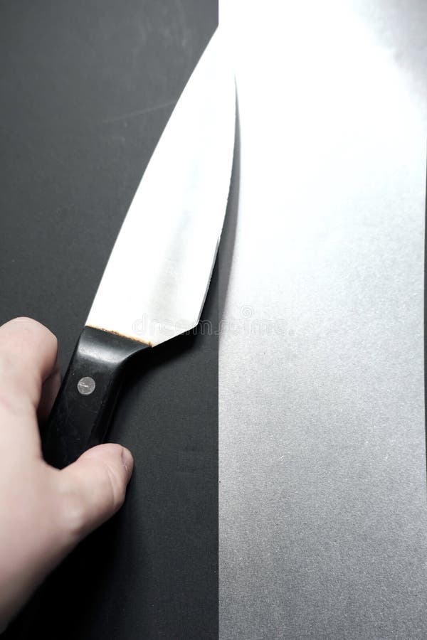 Vertical High Angle Shot of a Person Holding a Knife on a Black and ...