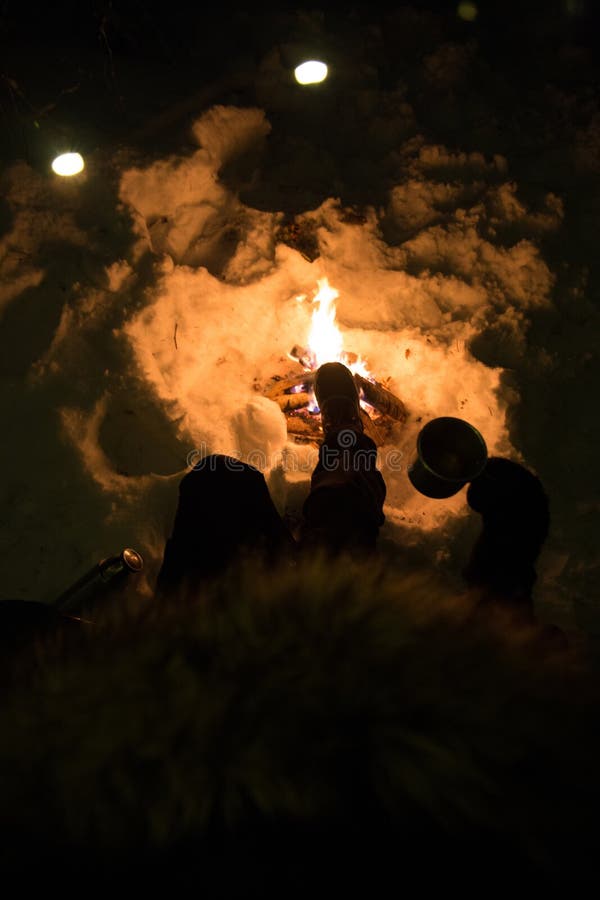 Vertical High Angle Shot of a Person Sitting by the Fire on the Snow ...