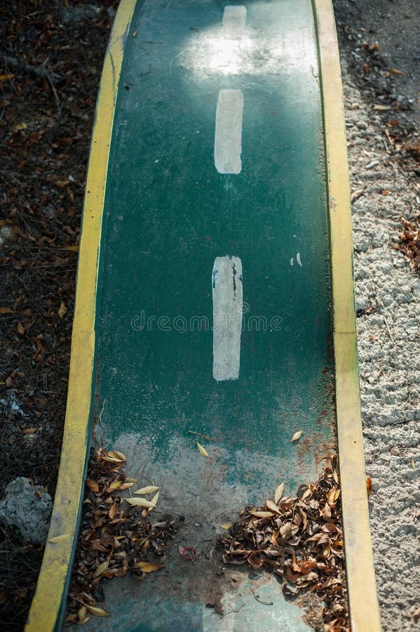 Vertical High Angle Shot of a Rusty Slide with Fallen Leaves on the ...