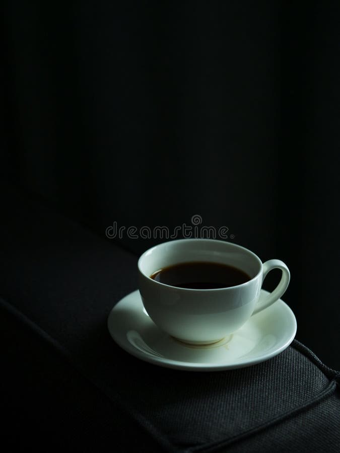 Vertical High Angle Shot of a White Instant Coffee Mug on a Black Couch ...