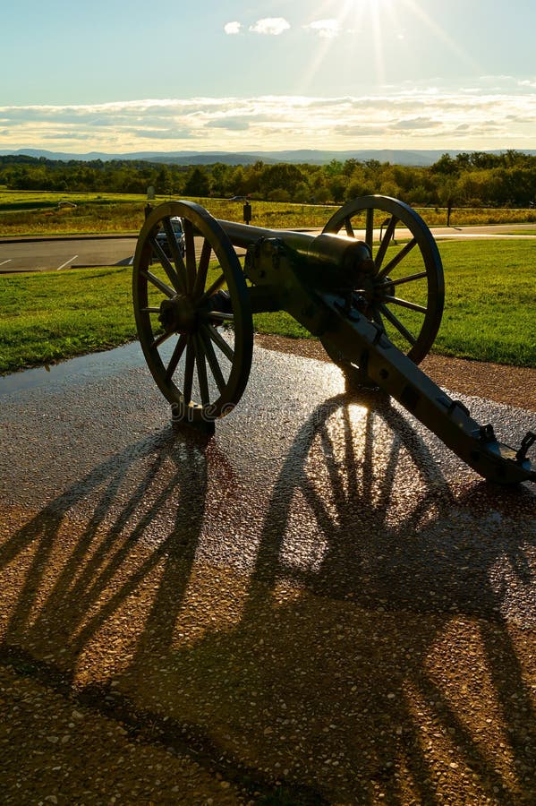 A Cannon Overlooking Field with Shadows Cast on the Ground Stock Photo ...