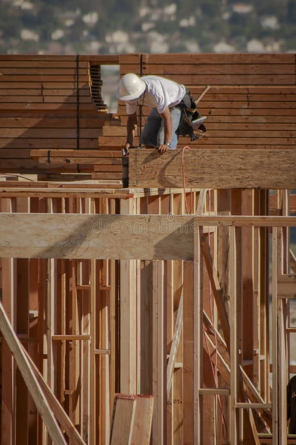 Vertical Image of a Construction Worker on Wood Framing with White Hard ...