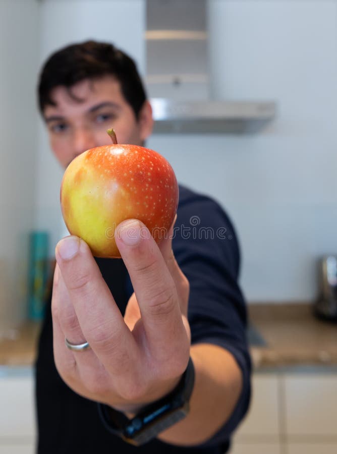Vertical Image of a Man Holding an Apple in the Kitchen Stock Image ...
