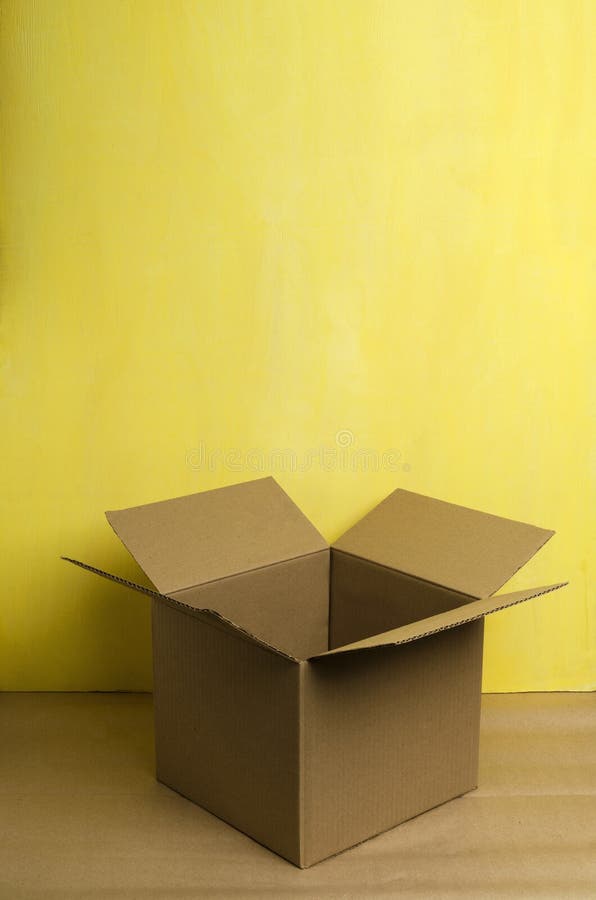 Vertical Image.Opened Empty Cardboard Box Against Yellow Background ...