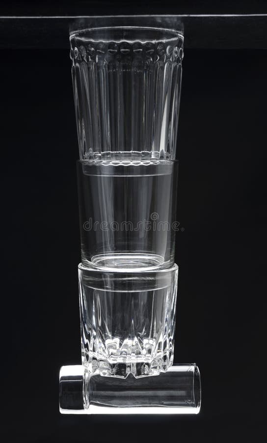 Vertical Image.Stack of Empty Glasses Against Dark Background Stock ...