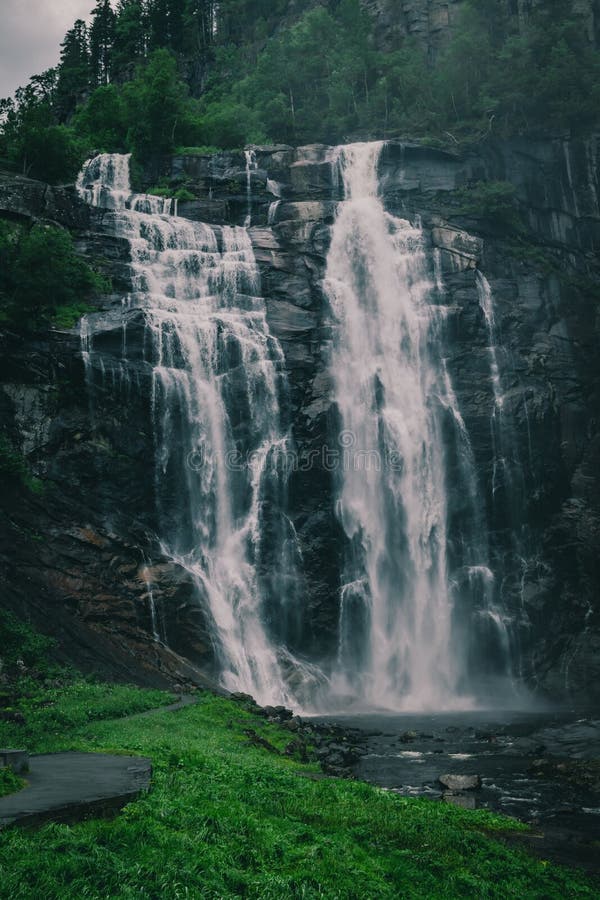 Vertical and Long Exposure Shot of a Waterfall in a Valley Emerging ...