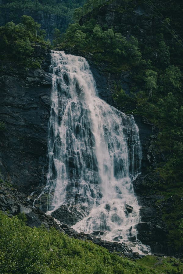 Vertical and Long Exposure Shot of a Waterfall in a Valley Emerging ...